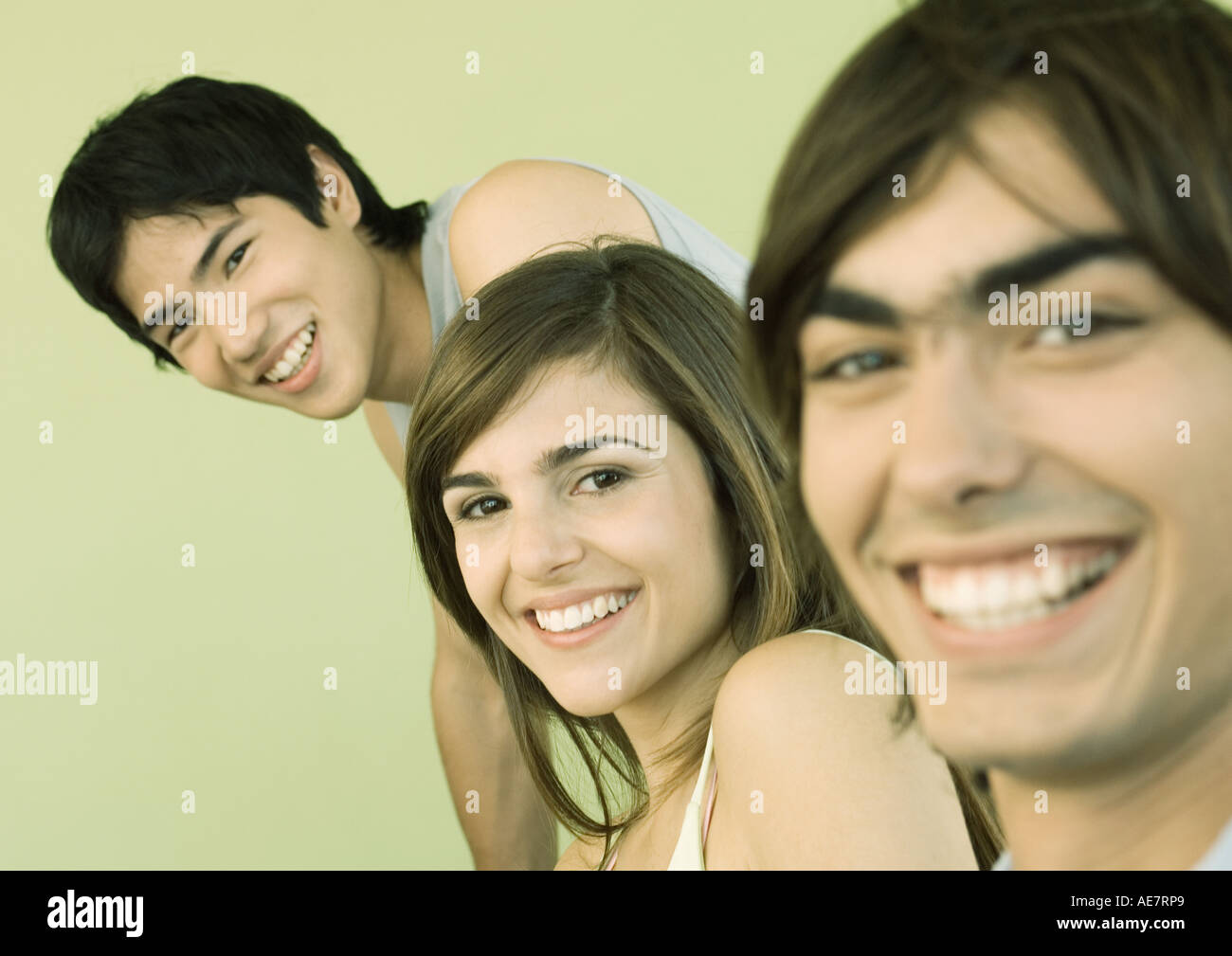 Three young adult friends smiling Stock Photo - Alamy