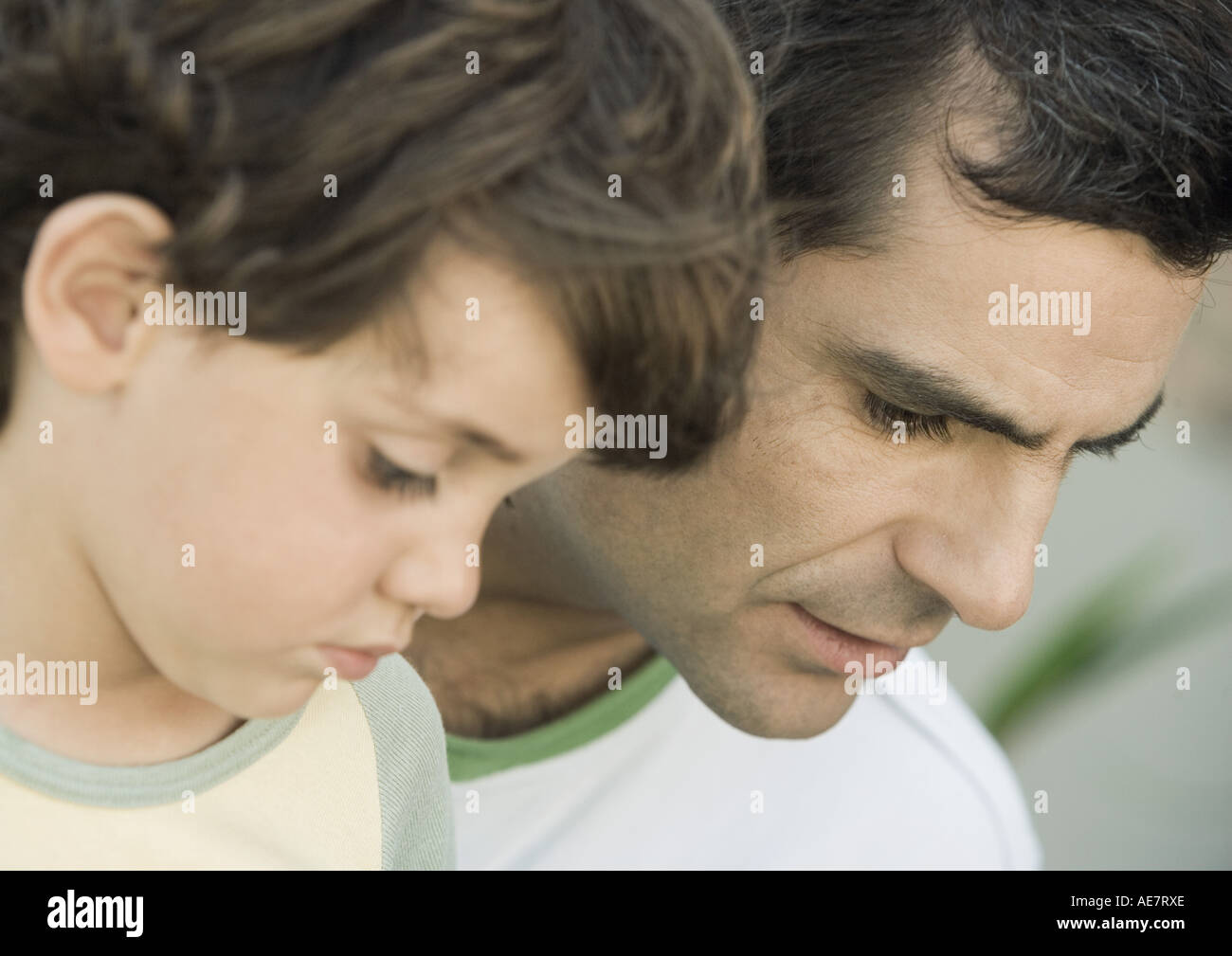 Father and son side by side and looking down together, side view ...