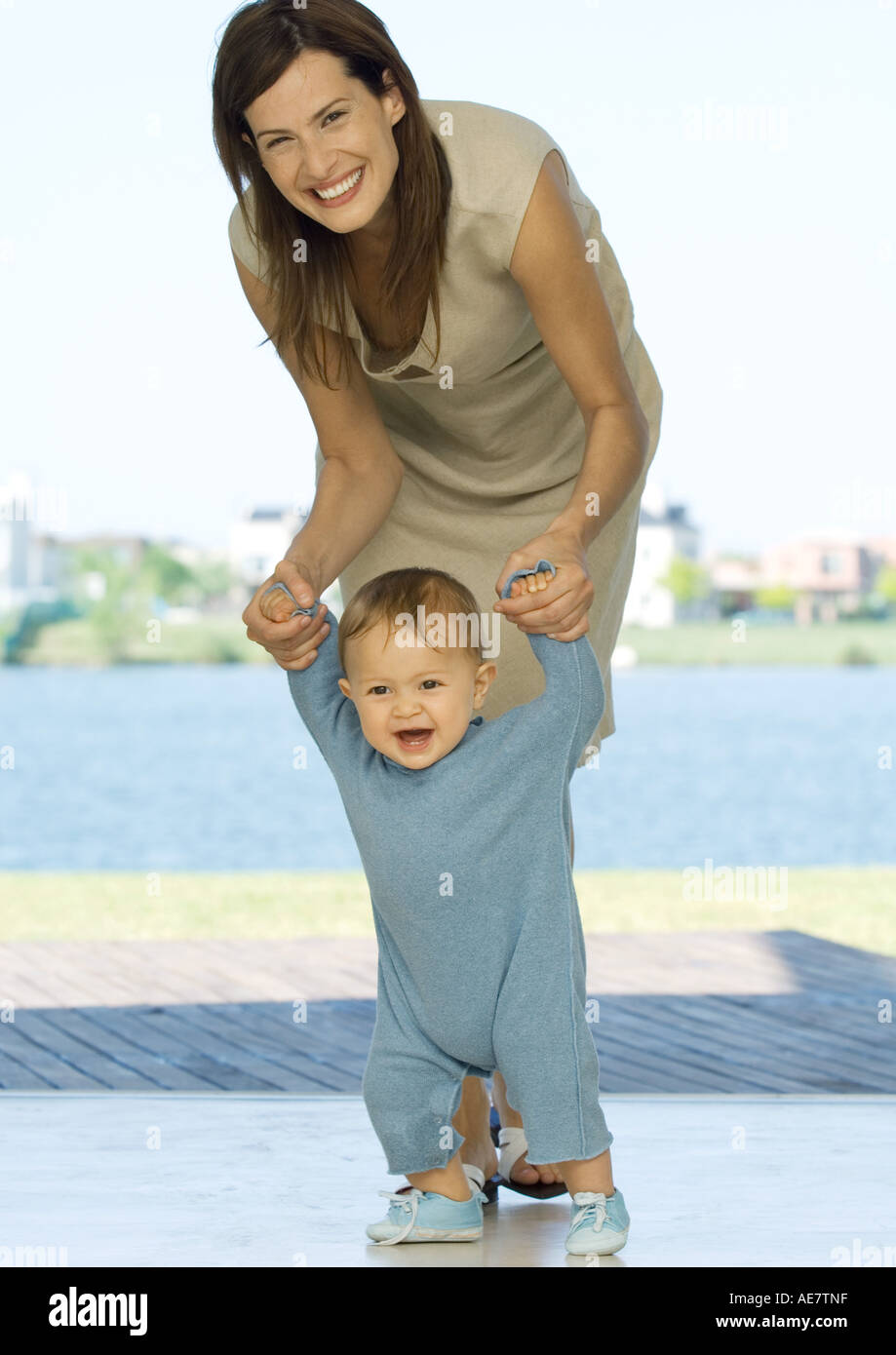 Mother helping baby walk Stock Photo - Alamy