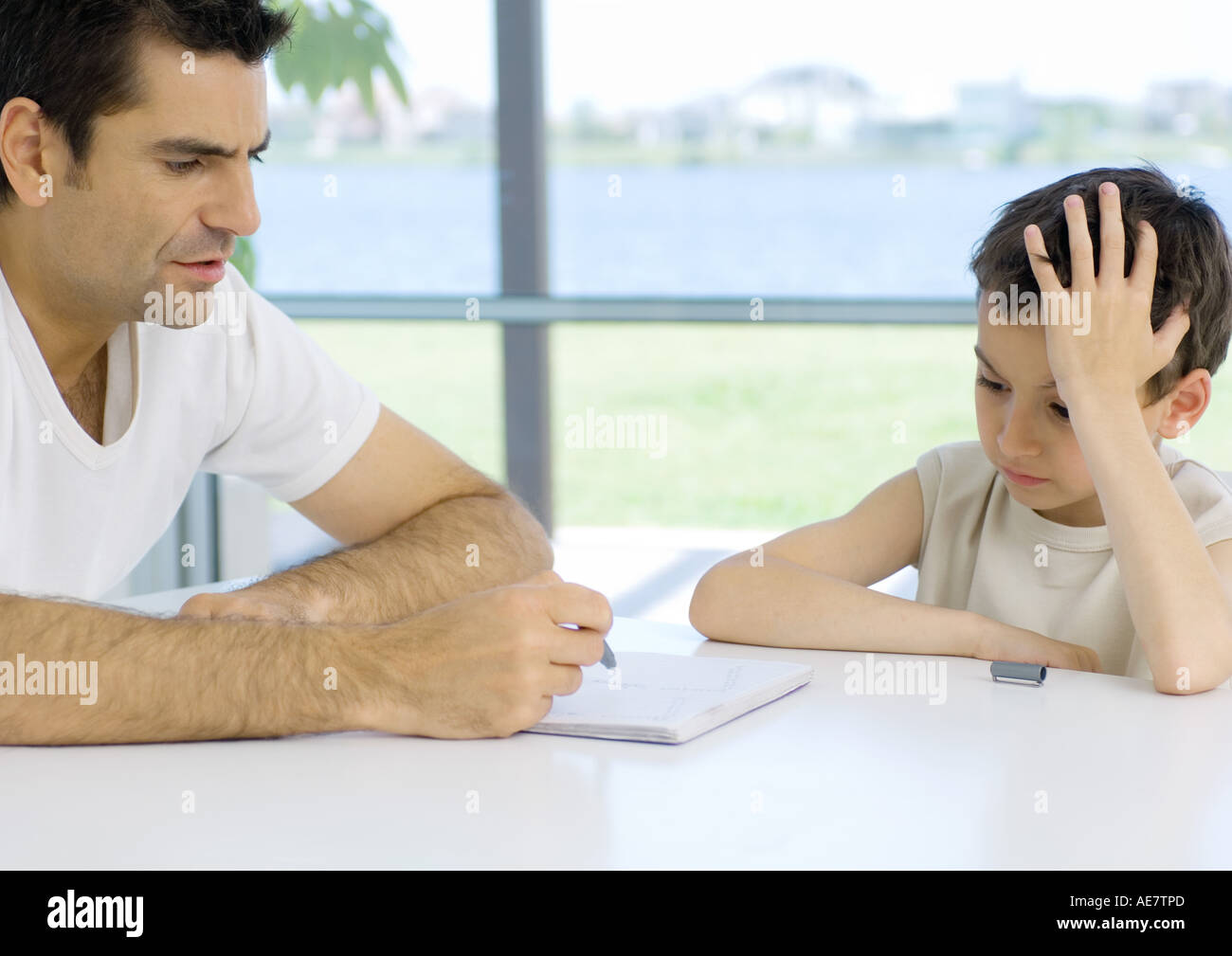 Boy doing homework with father's help, cropped Stock Photo - Alamy