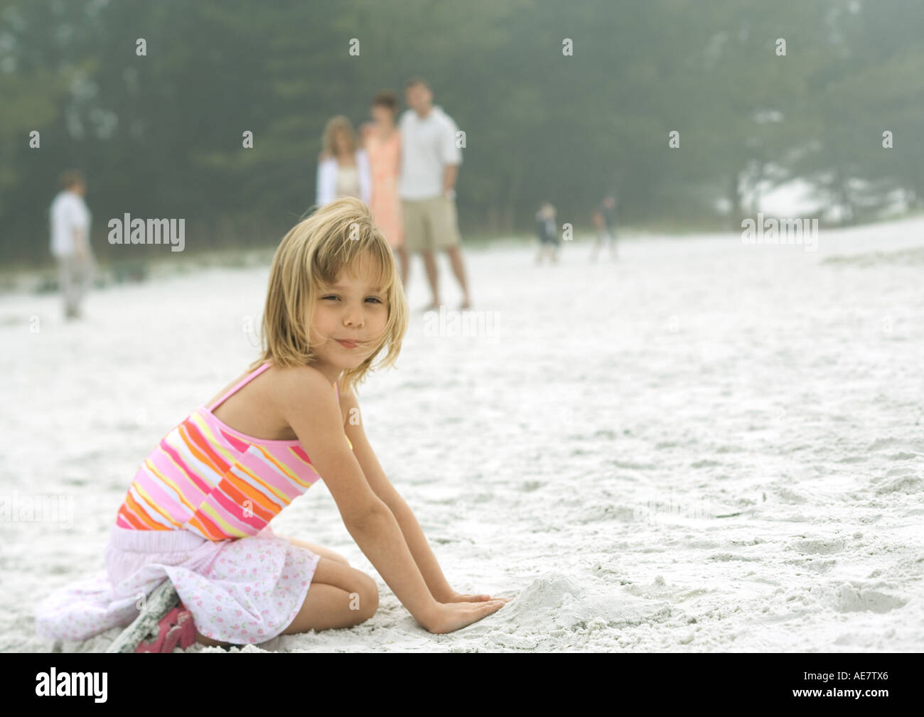 Little girl playing in sand Stock Photo - Alamy
