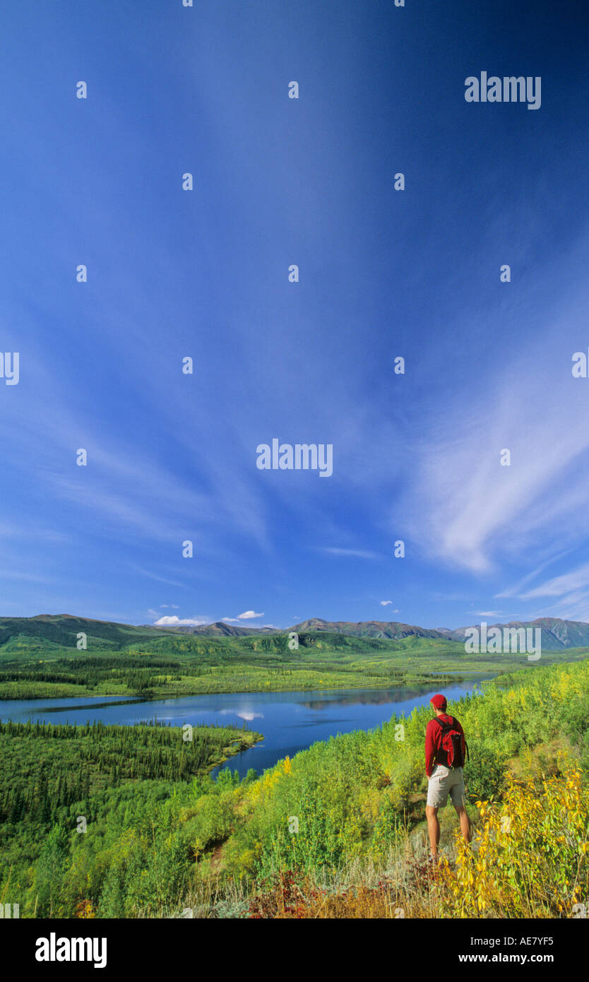 Hiker by Bruce Lake and the St Cyr Mountain Range Yukon Territory ...