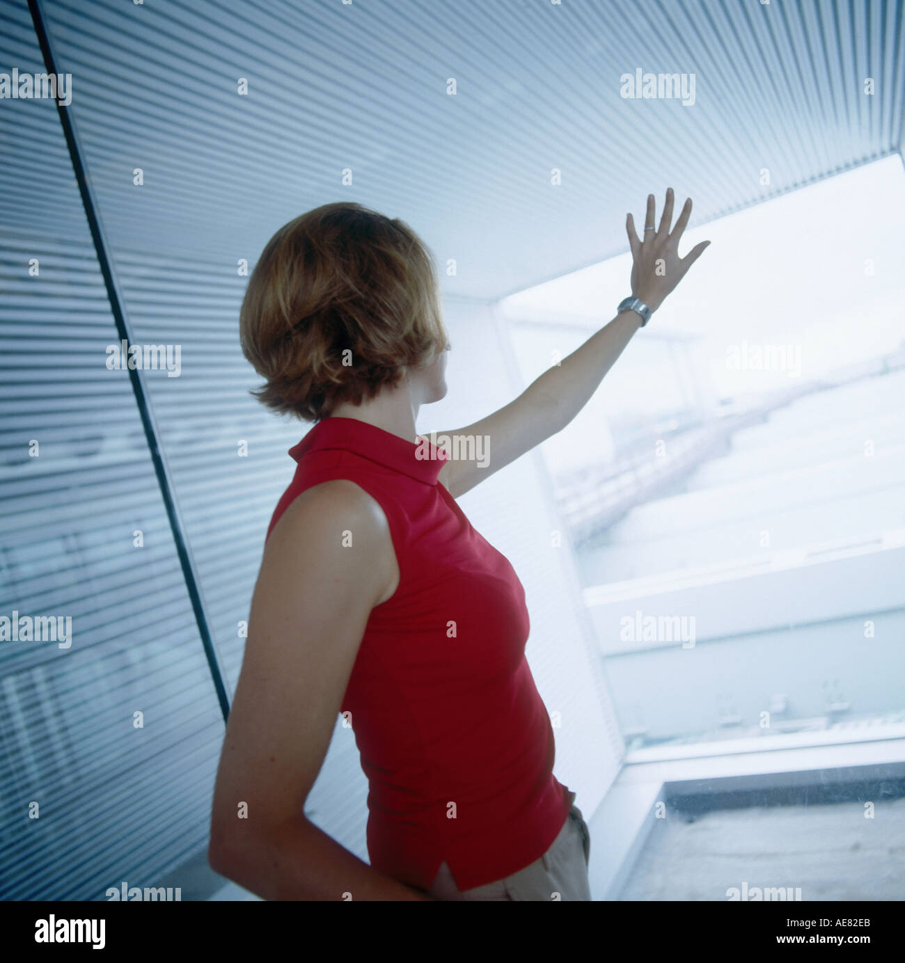Side profile of businesswoman leaning against window glass Stock Photo ...