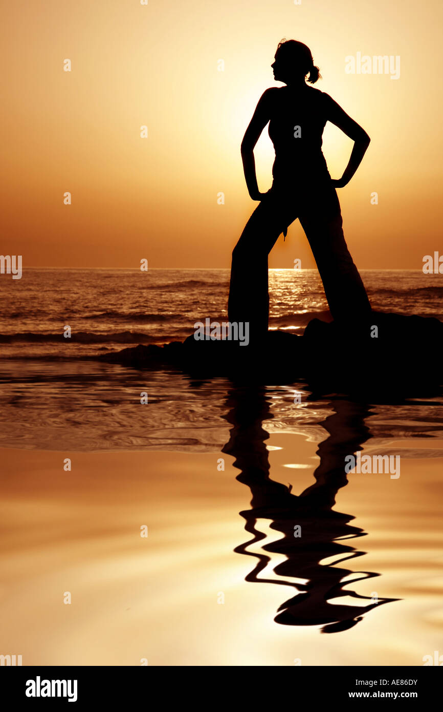 Woman in yoga pose with sunset and reflection Stock Photo - Alamy