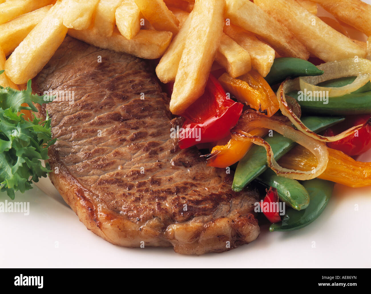 Pan fried sirloin steak onions chips peppers mange tout hi-res stock ...