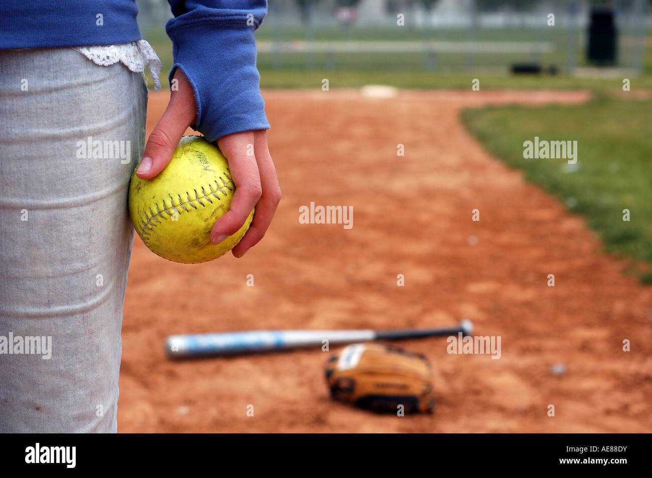 A girl holds a softball on the infield diamond Stock Photo - Alamy