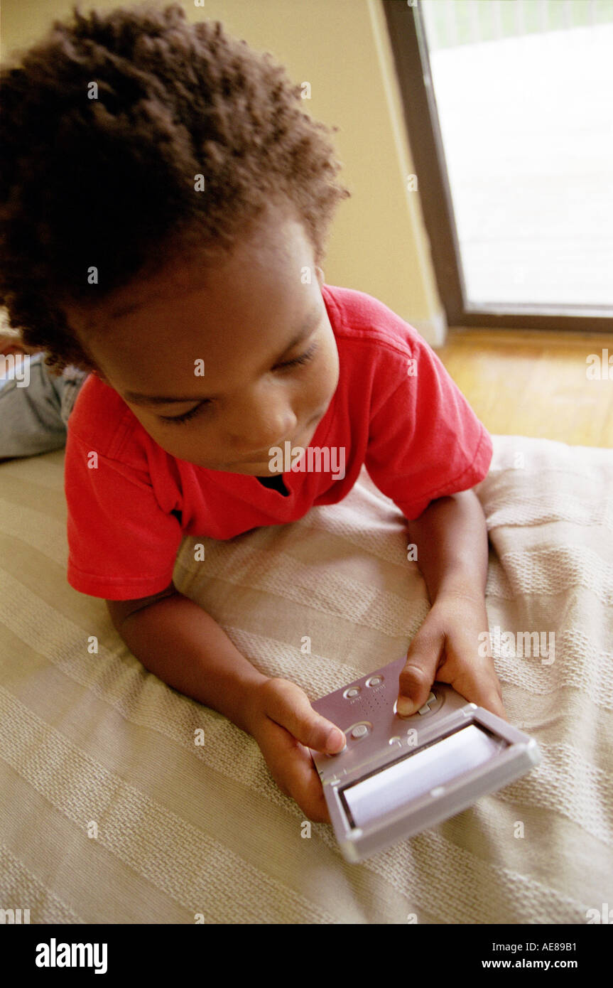 African American Black Boy in red shirt playing gameboy Young boy Stock ...