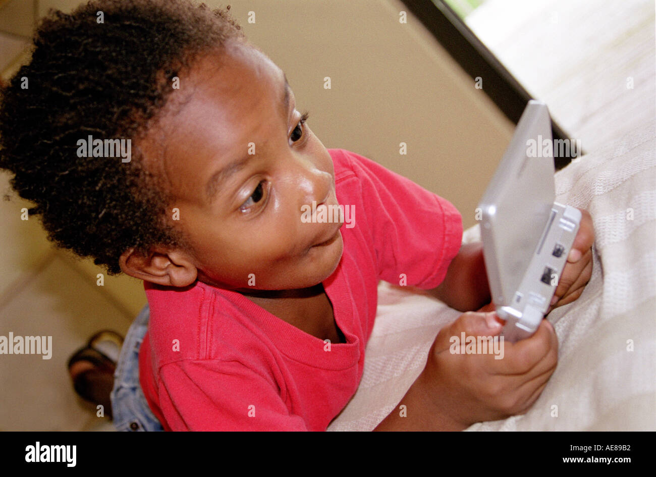 African American Black Boy in red shirt playing gameboy Young boy Stock ...