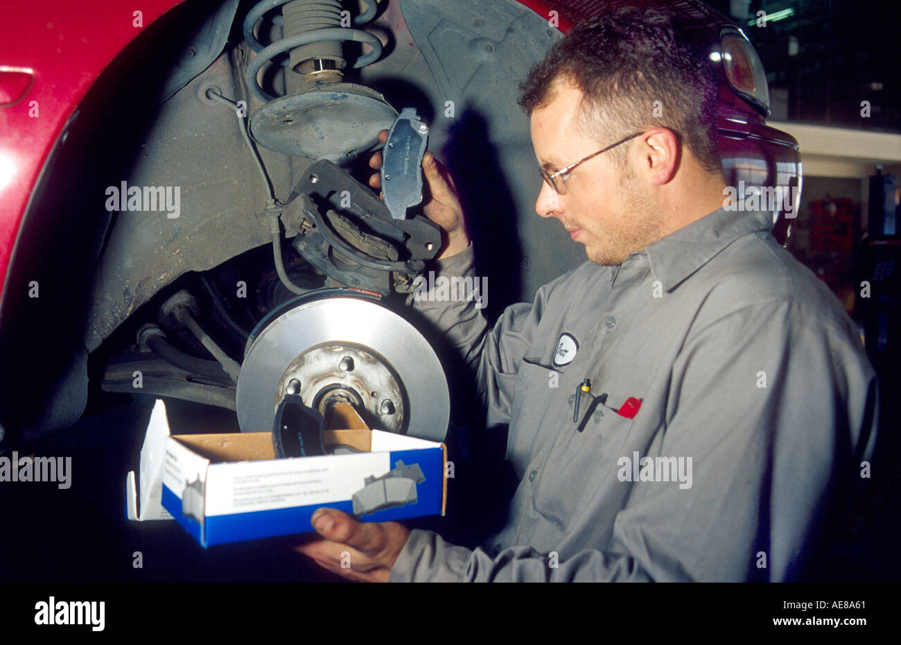 An auto mechanic inspecting and changing brake pads Stock Photo - Alamy