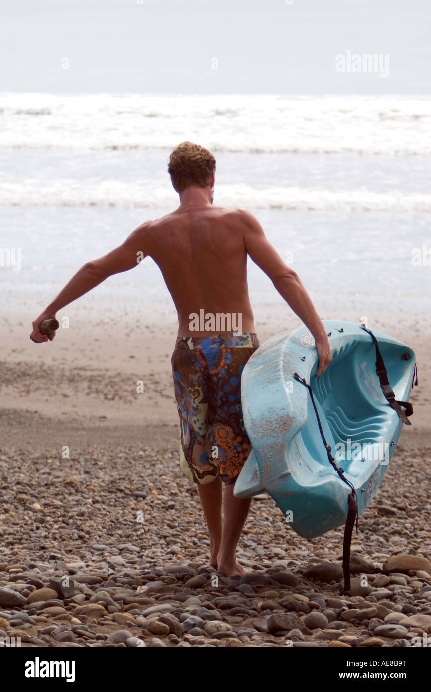 male walking with a ocean kayak Stock Photo - Alamy