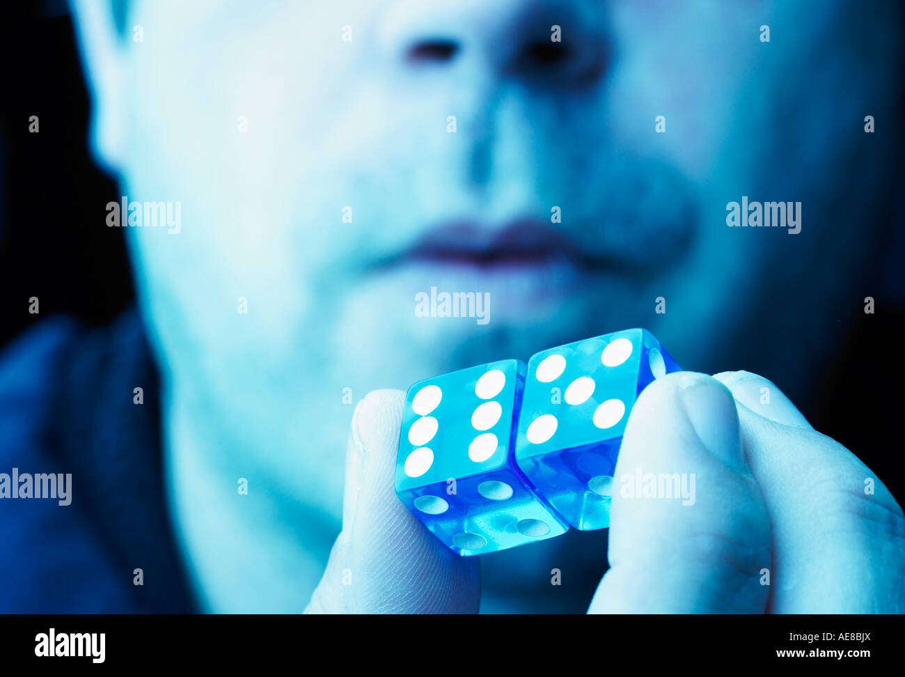 man blowing on dice for luck Stock Photo - Alamy