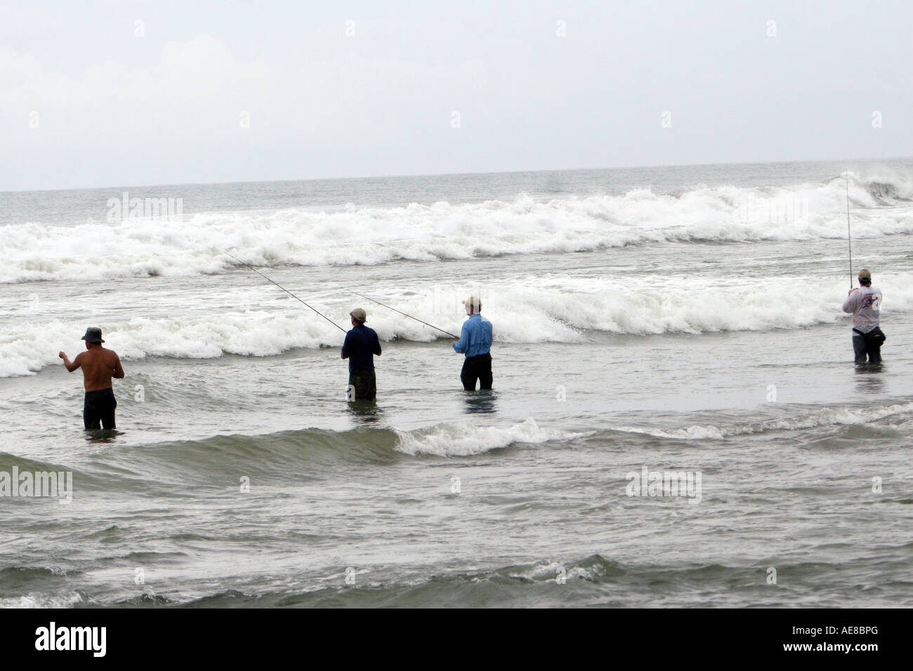 Men fishing at the beach by the ocean.pole Stock Photo - Alamy