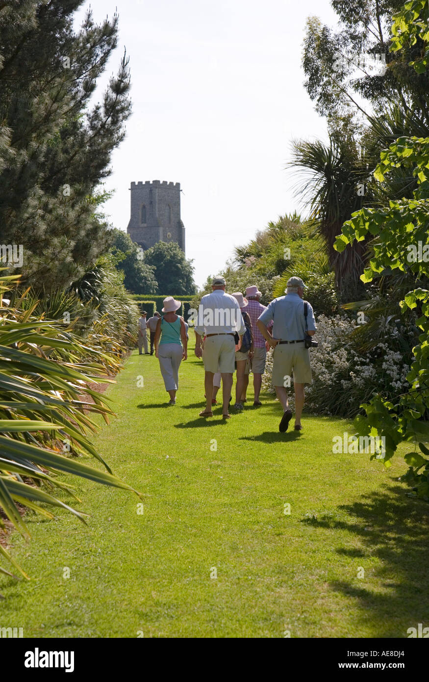 Group of People Walking in Gardens with View of Church in Distance ...