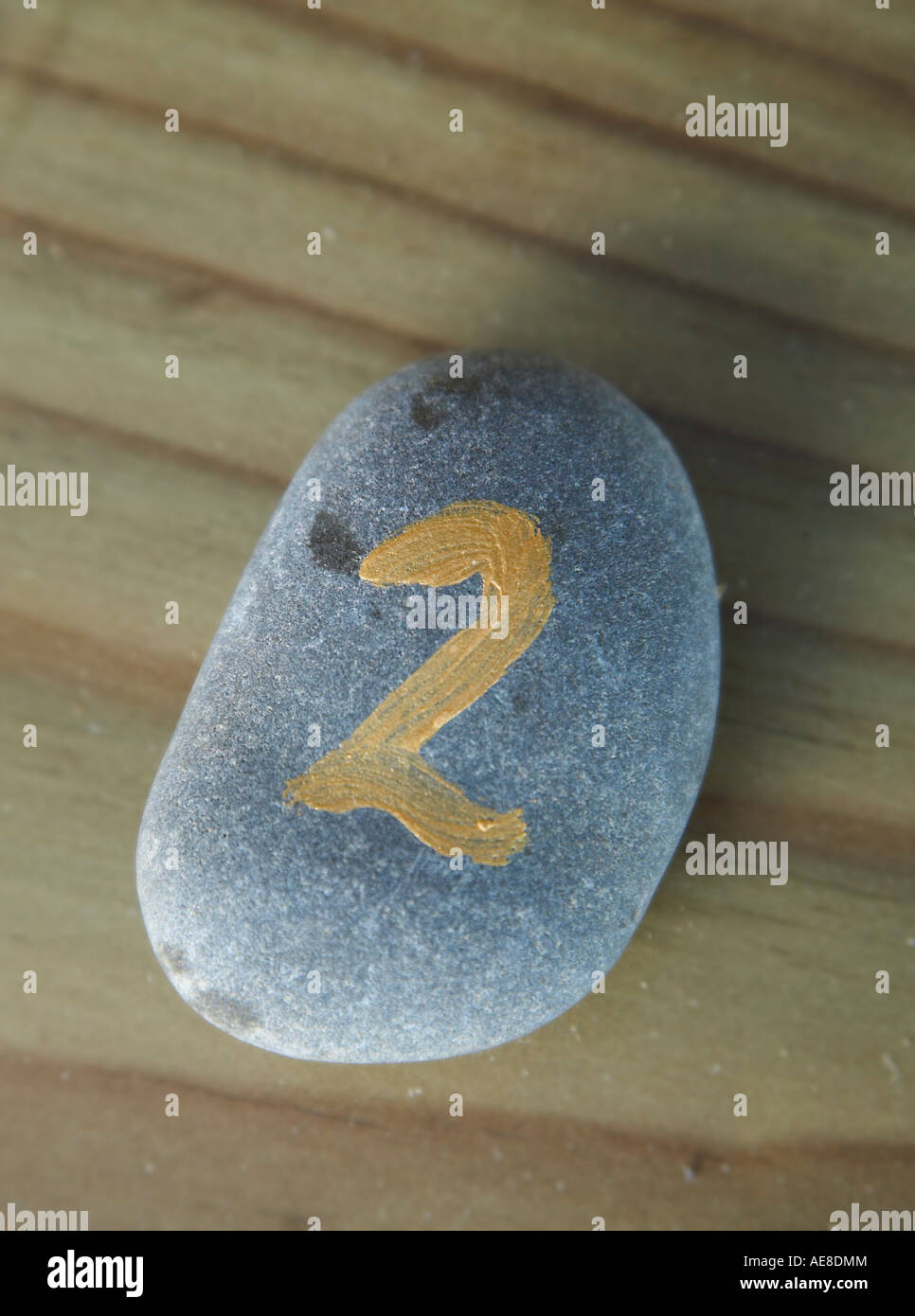 stone with number two painted on in gold paint Stock Photo - Alamy