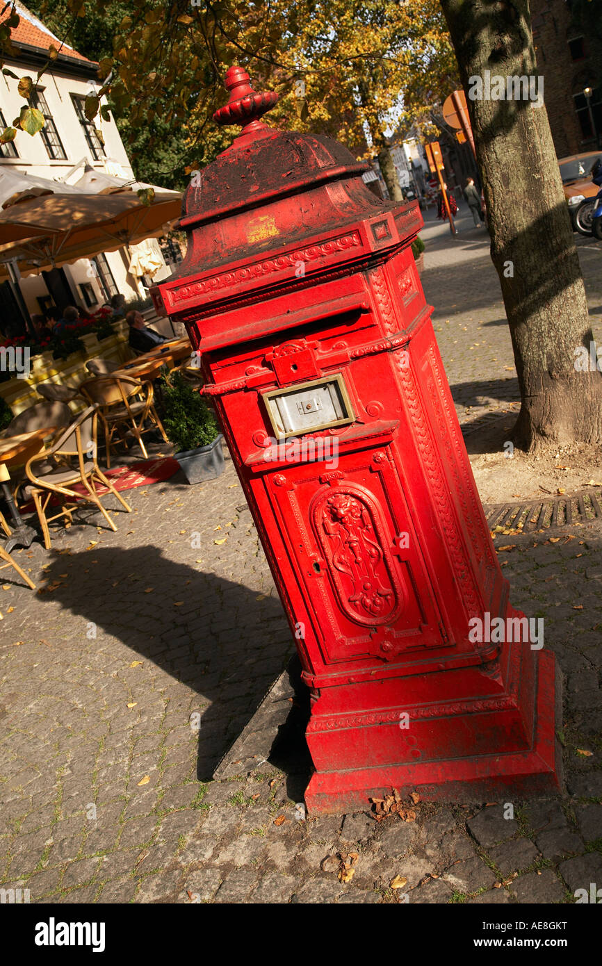 Old style red letter box mail box on pavement with outside cafe in ...