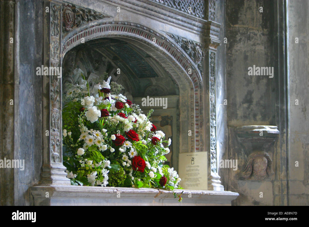 Flowers decorating ancient niche of knight's tomb in Lacock church ...
