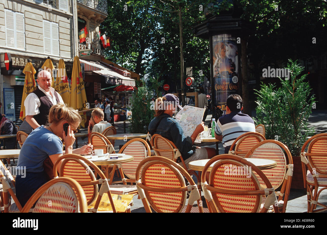 Sitting at a roadside cafe in central Paris Drinking coffee reading ...