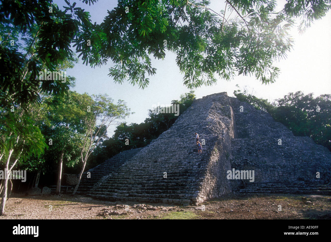 Two people descending steps from the pyramid at Coba in Yucatan Mexico ...