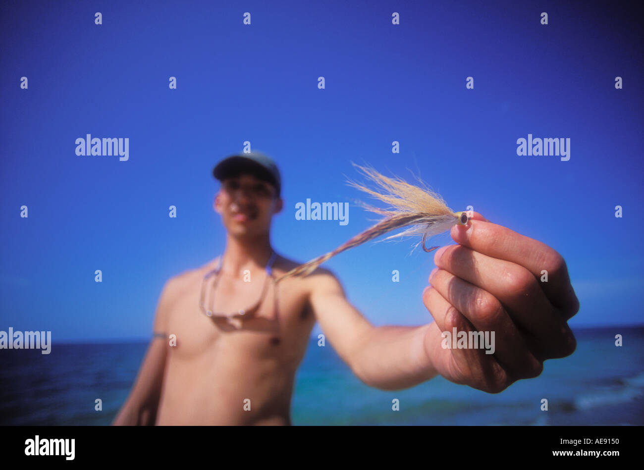 Man holding fly used for fly fishing Baja California Mexico Model ...