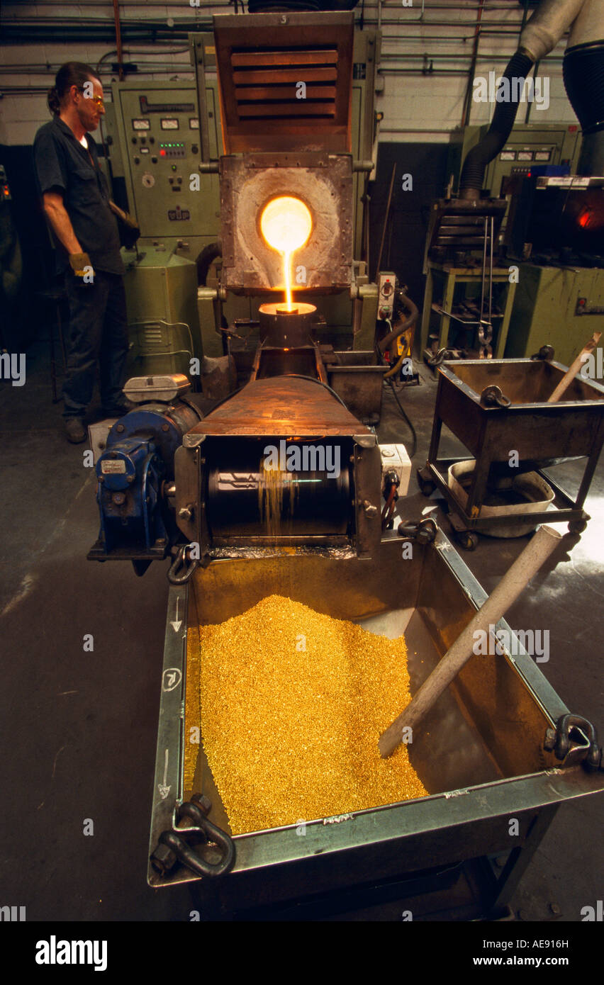 Pouring gold through perforated crucible into water bath to produce ...