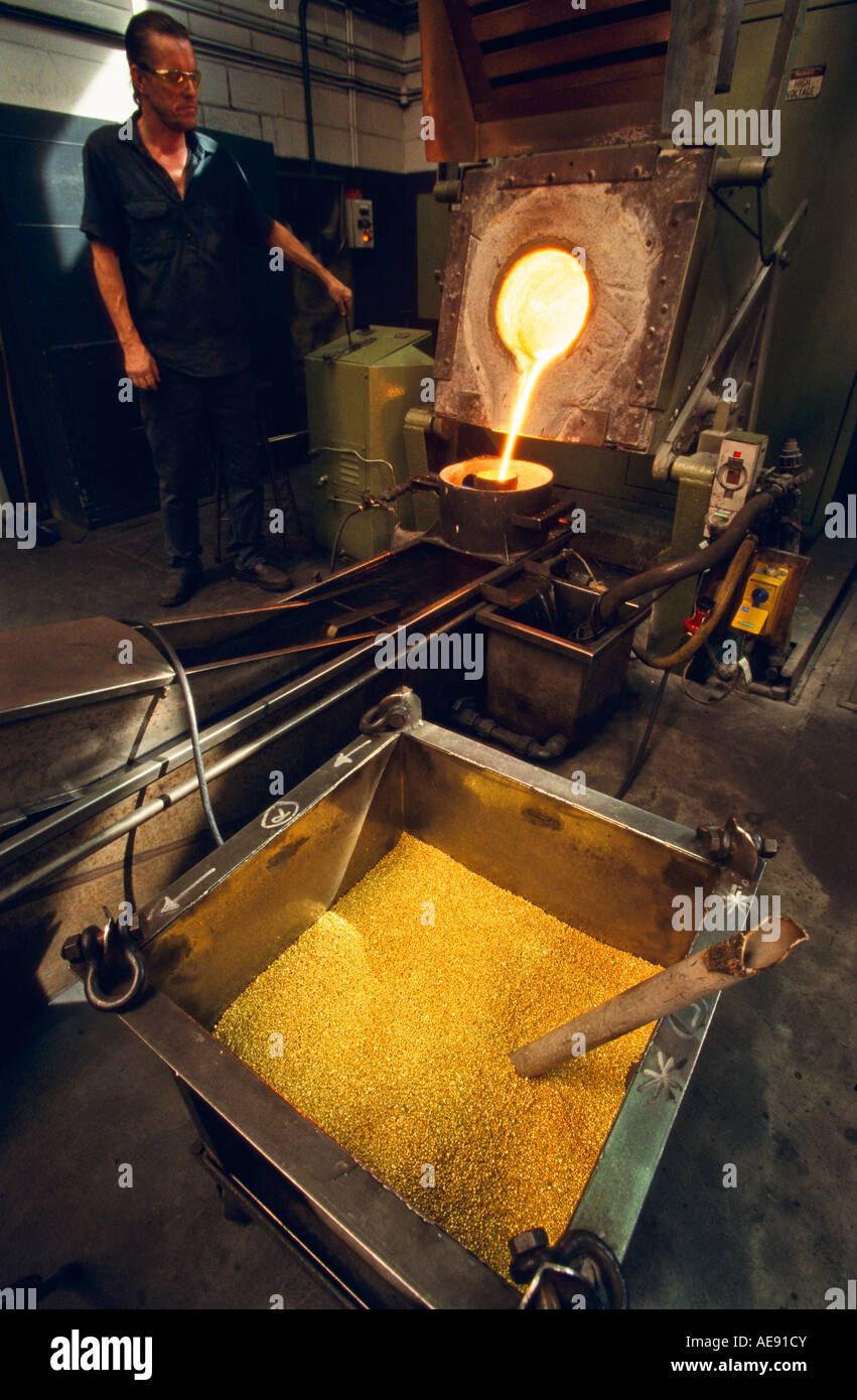 Pouring gold through perforated crucible into water bath to produce ...