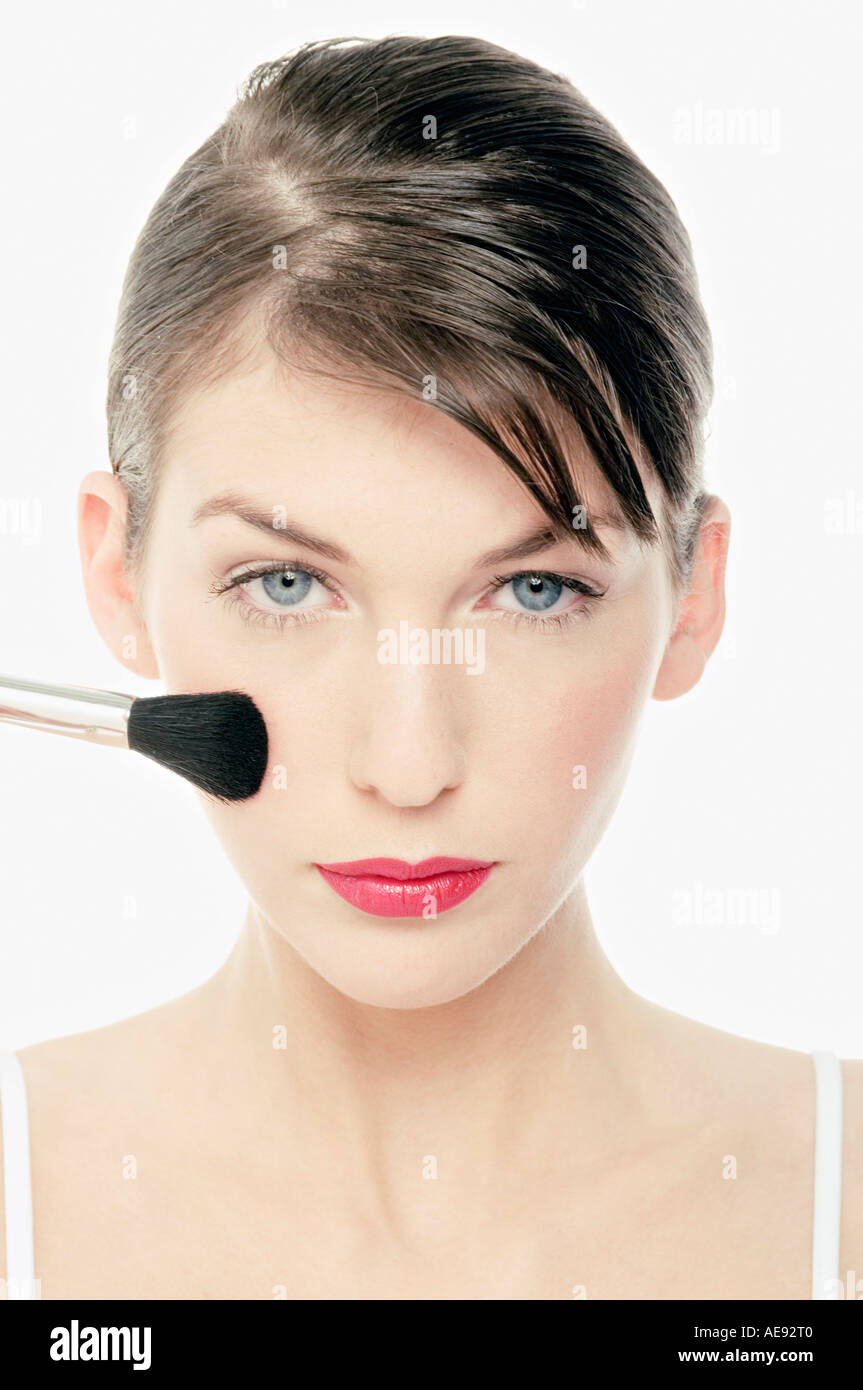 Young Woman face making-up with a brush, close-up (studio Stock Photo ...