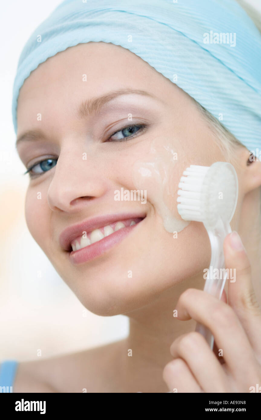 Young Woman face looking at the camera, cleaning her cheeks with a ...