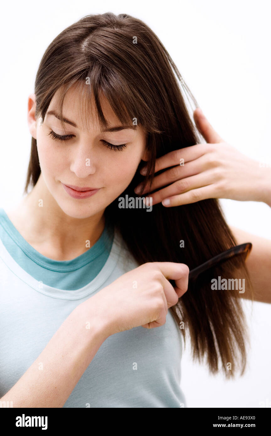 Portrait of a young woman combing her hair Stock Photo - Alamy