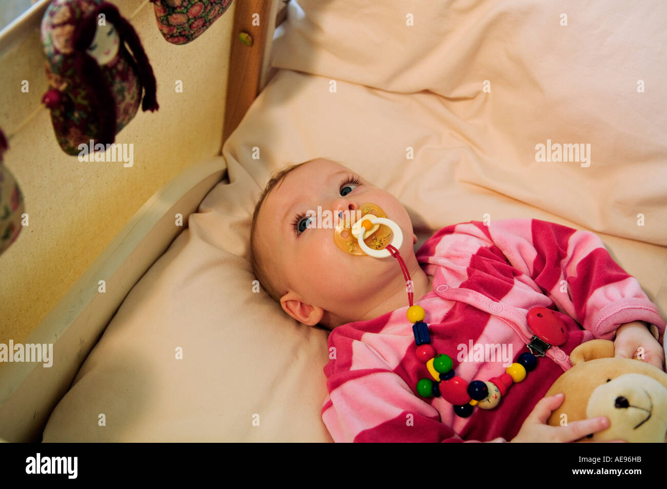 Baby in bed with comforter Stock Photo - Alamy