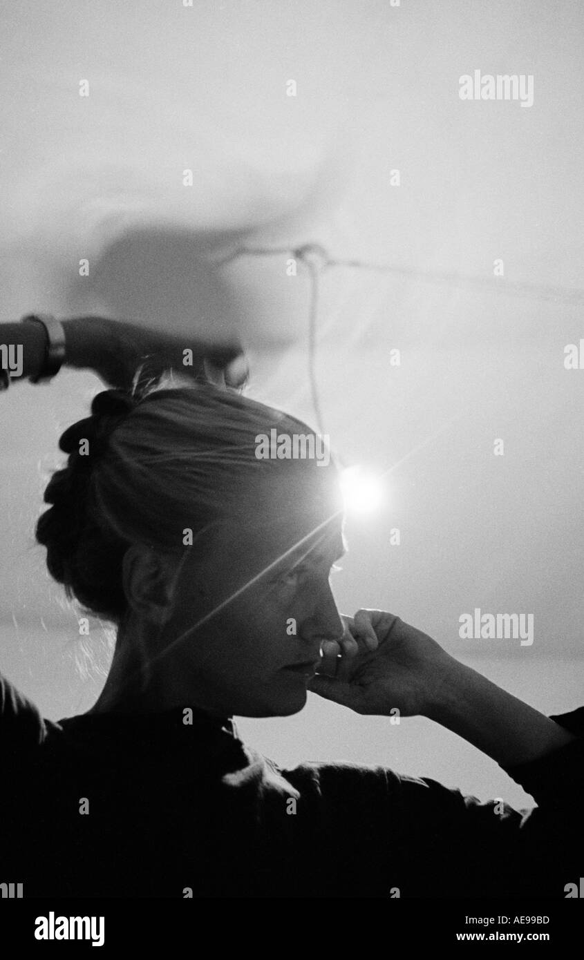 A beautiful woman with a topknot in direct light Stock Photo - Alamy