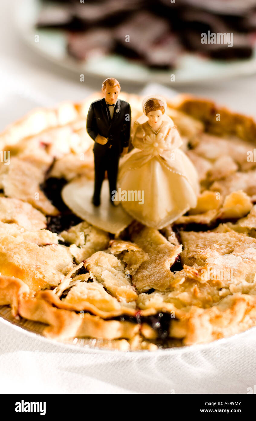 Pie with plastic bride and groom on top Stock Photo - Alamy