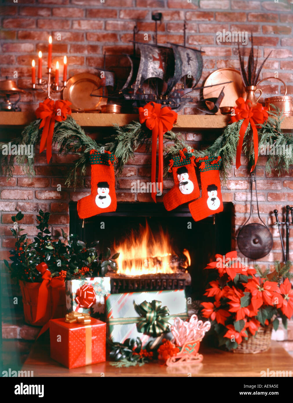 Christmas still life with blazing fireplace and stockings hung from the ...