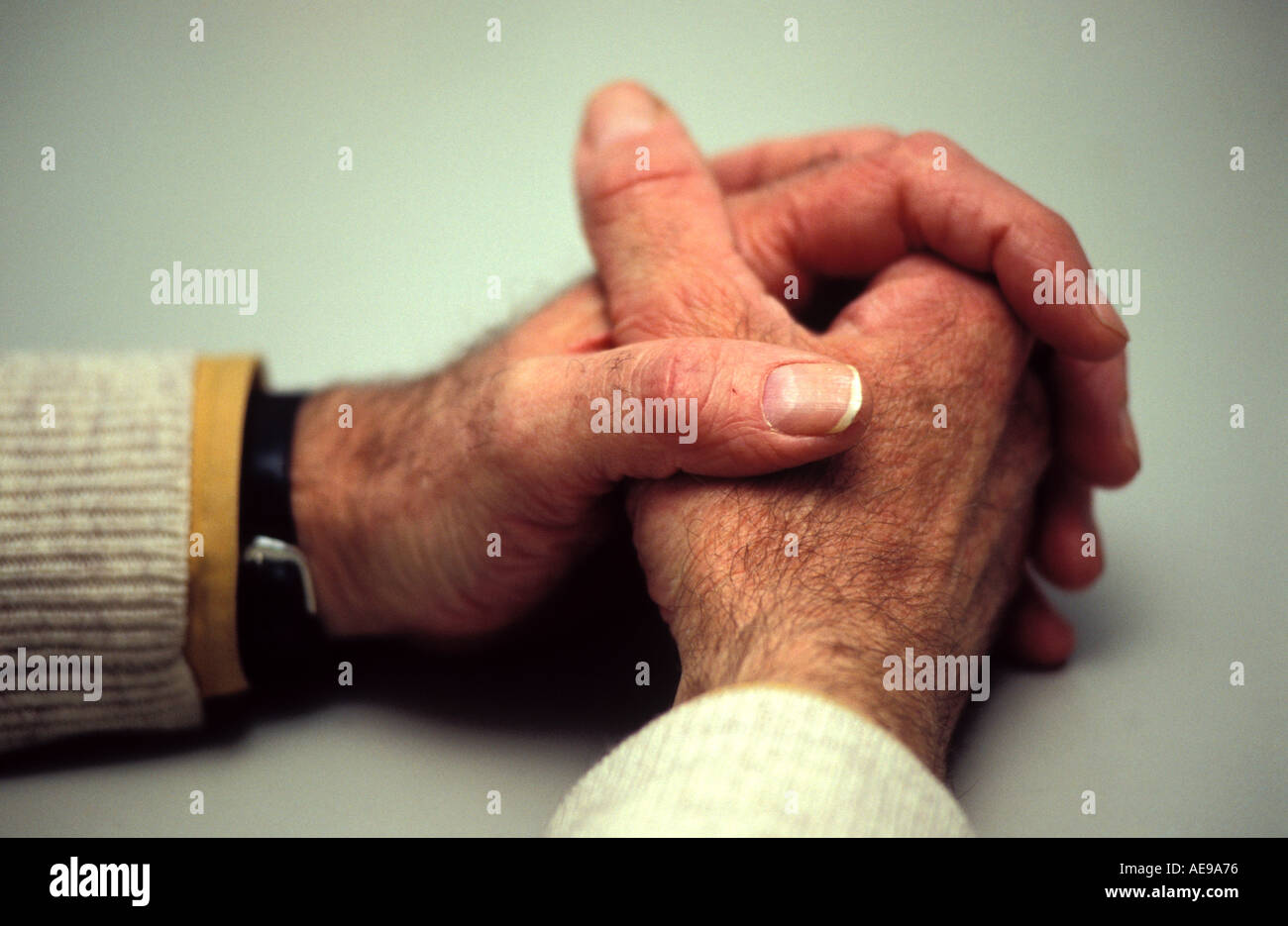 Elderly man clasping hands London UK Stock Photo - Alamy
