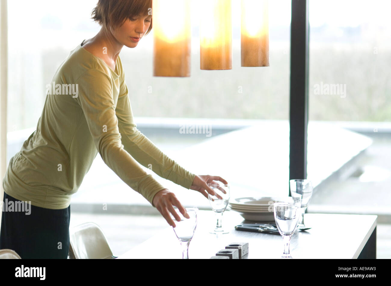 Young woman setting the table Stock Photo - Alamy