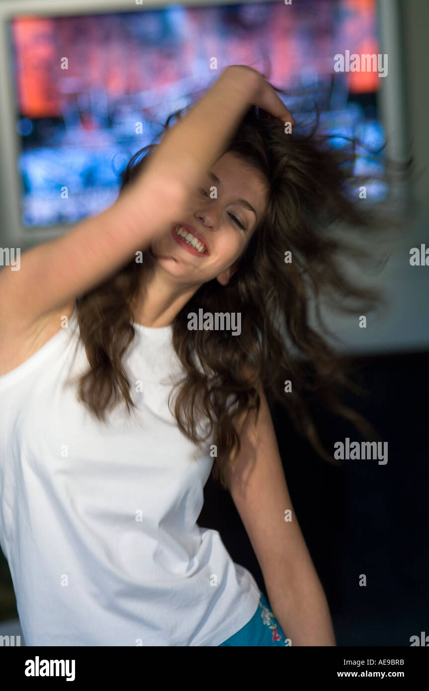 Young smiling woman in white tank top dancing, blurred motion Stock ...