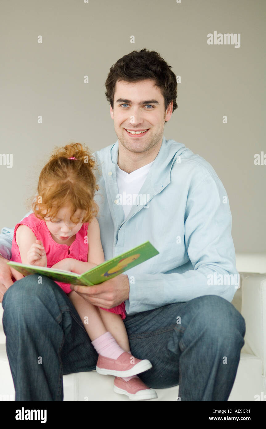 Man and little girl reading children's book Stock Photo - Alamy