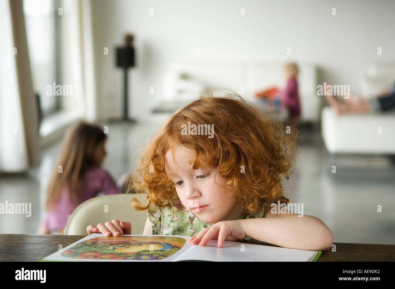 Little girl reading children's book Stock Photo - Alamy