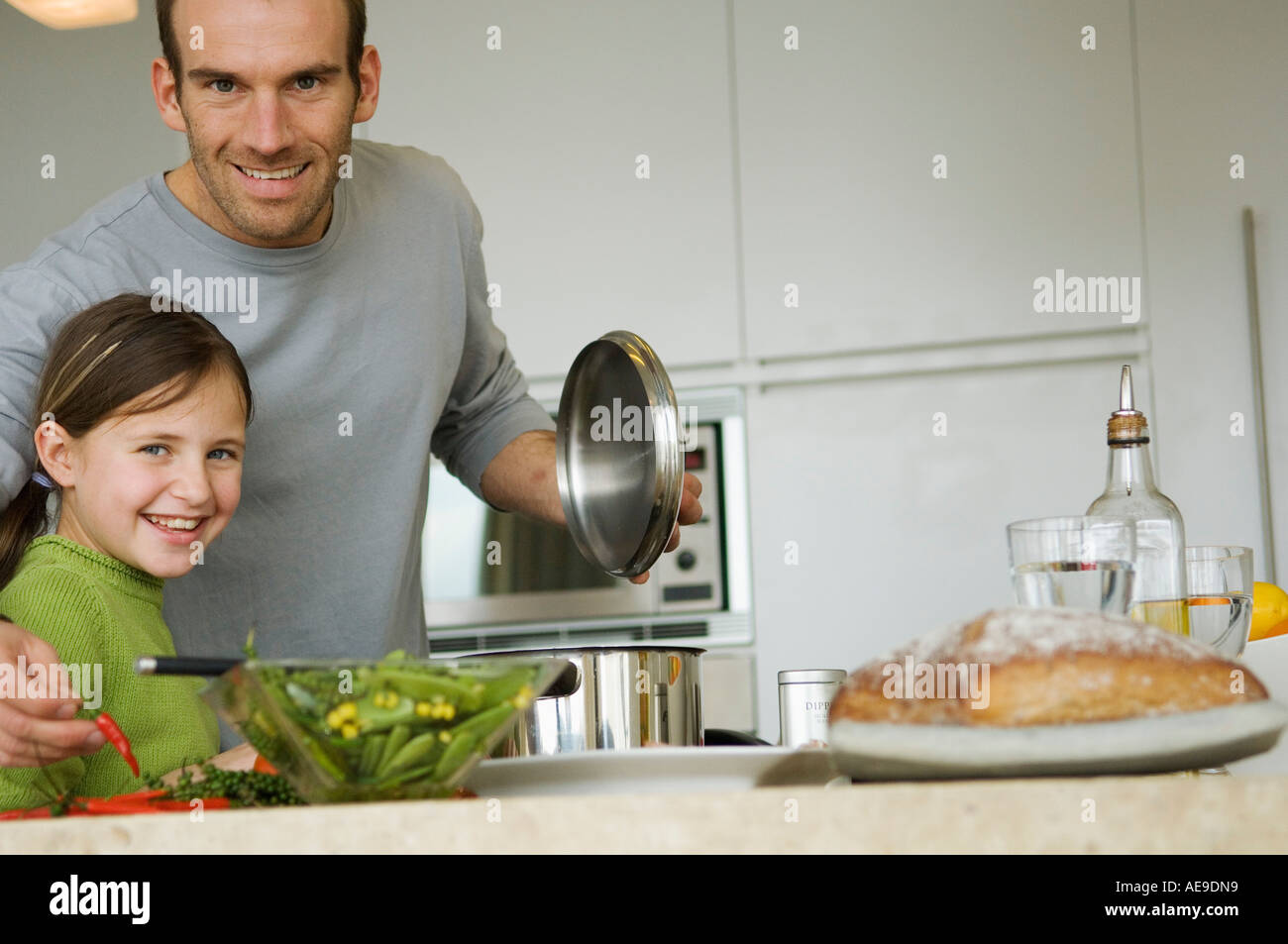 Man and little girl cooking, smiling for the camera Stock Photo - Alamy