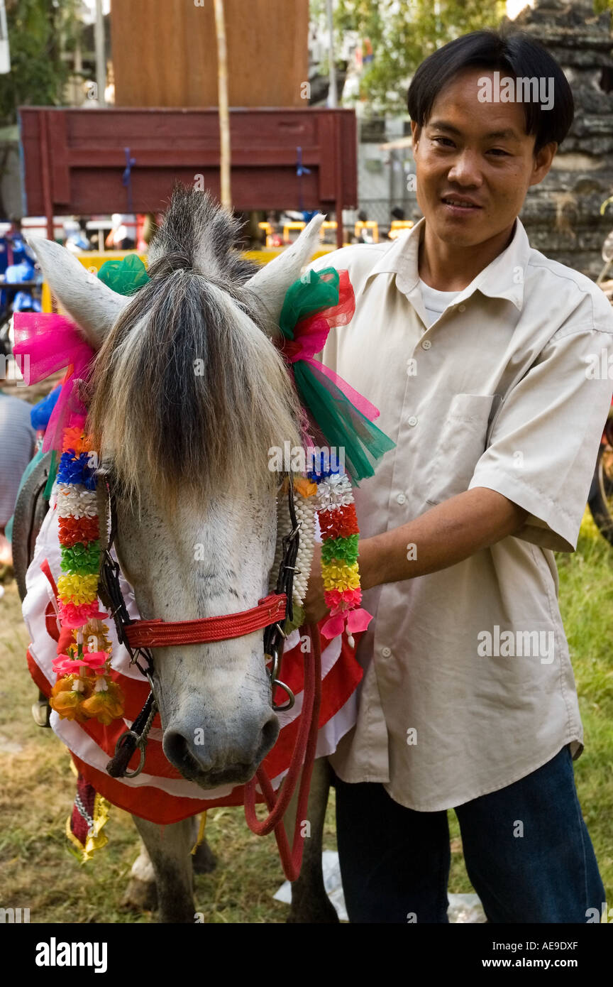 A man poses with a Chinese pony at Wat Pa Pao during the Poi Sang Long ...