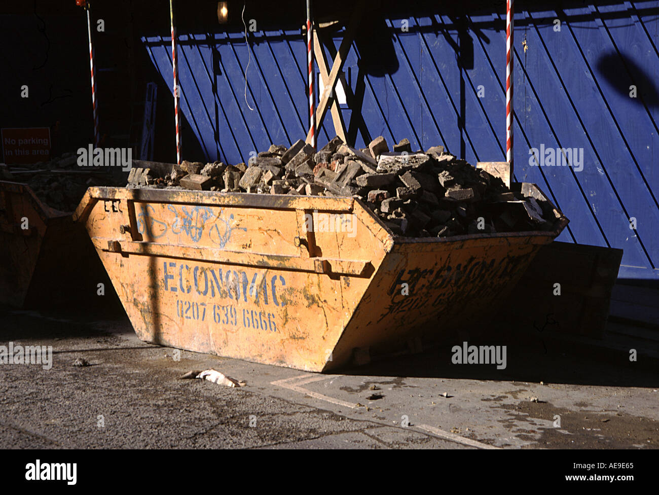 Yellow skip in a London street Stock Photo - Alamy