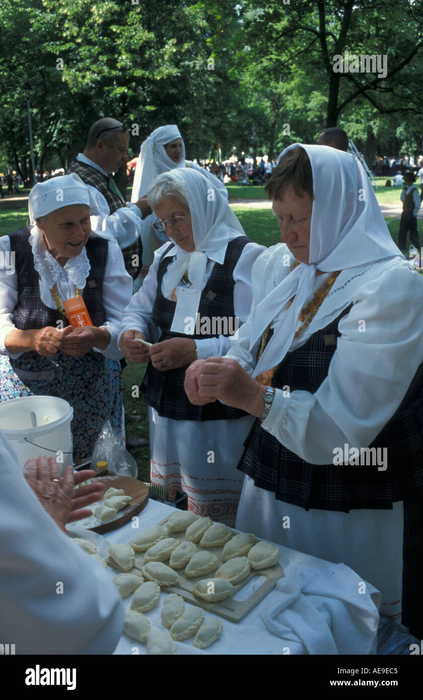 Lithuanian women dressed in folk costume prepare a traditional dish in ...