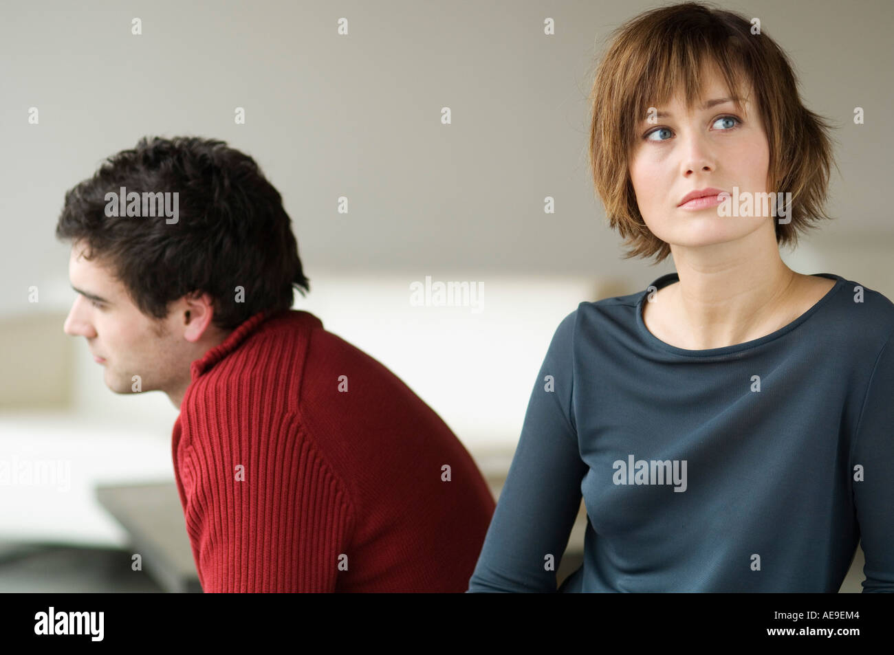 Sad looking couple in a living-room Stock Photo - Alamy