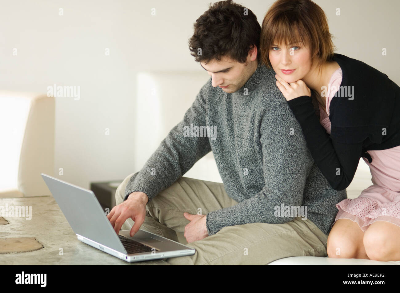 Man using laptop computer, woman resting on his shoulder Stock Photo ...