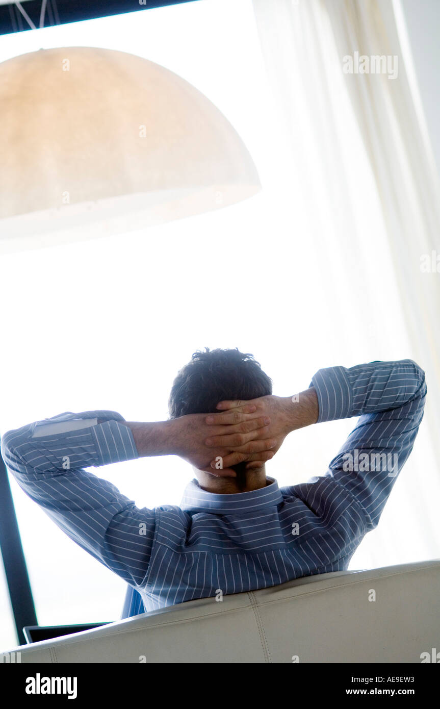 Man resting on a sofa, rear view Stock Photo - Alamy