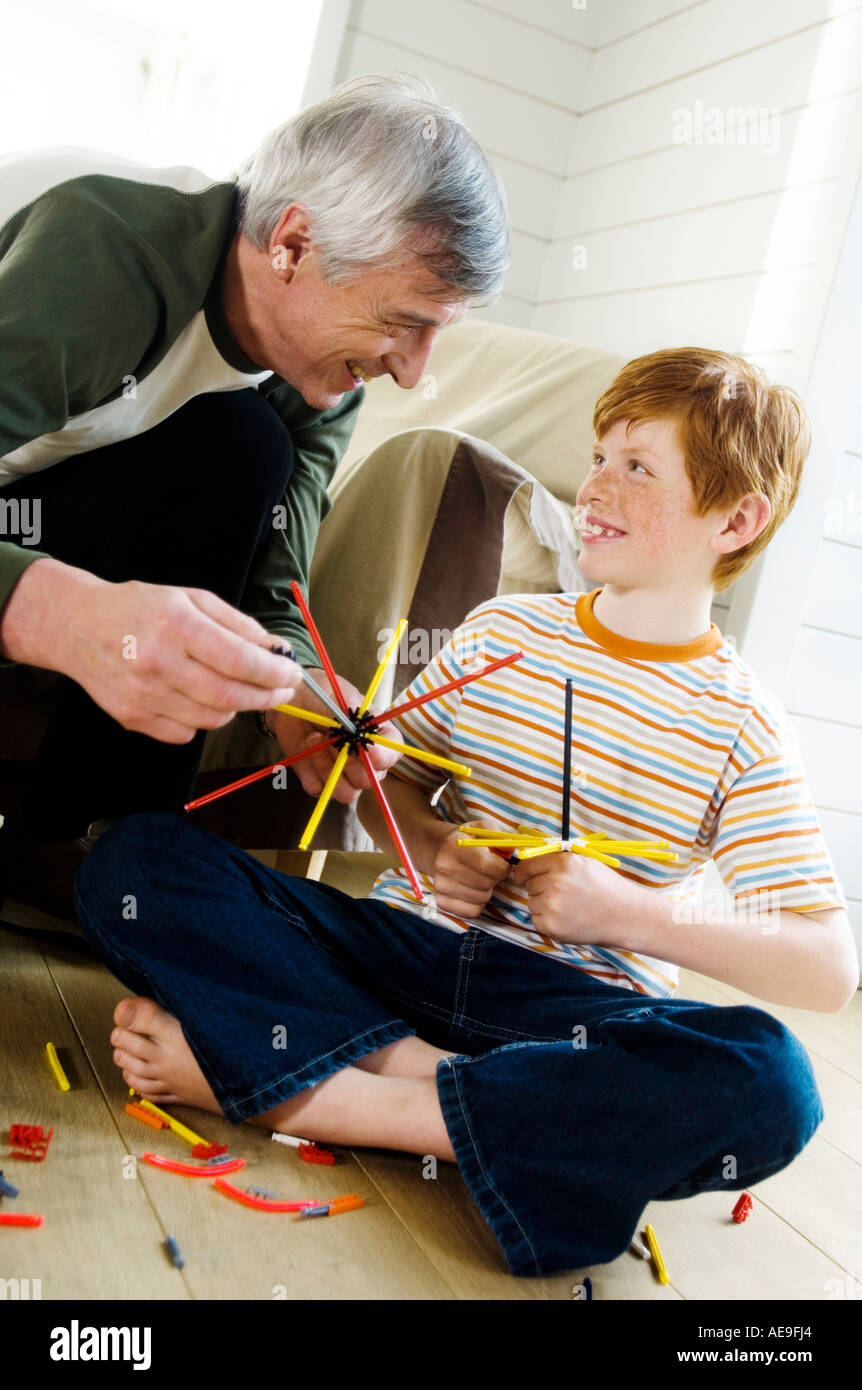 Senior man and boy playing construction game indoors Stock Photo - Alamy