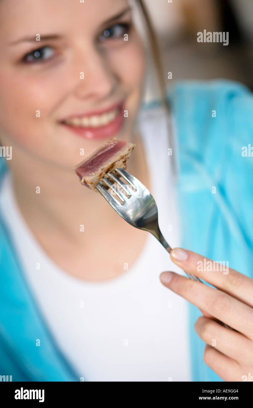 Portrait of a woman eating meat Stock Photo - Alamy