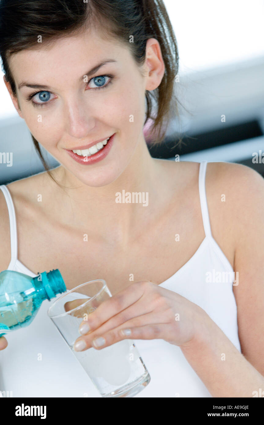 Portrait of a young smiling woman pouring water into a glass Stock Photo - Alamy