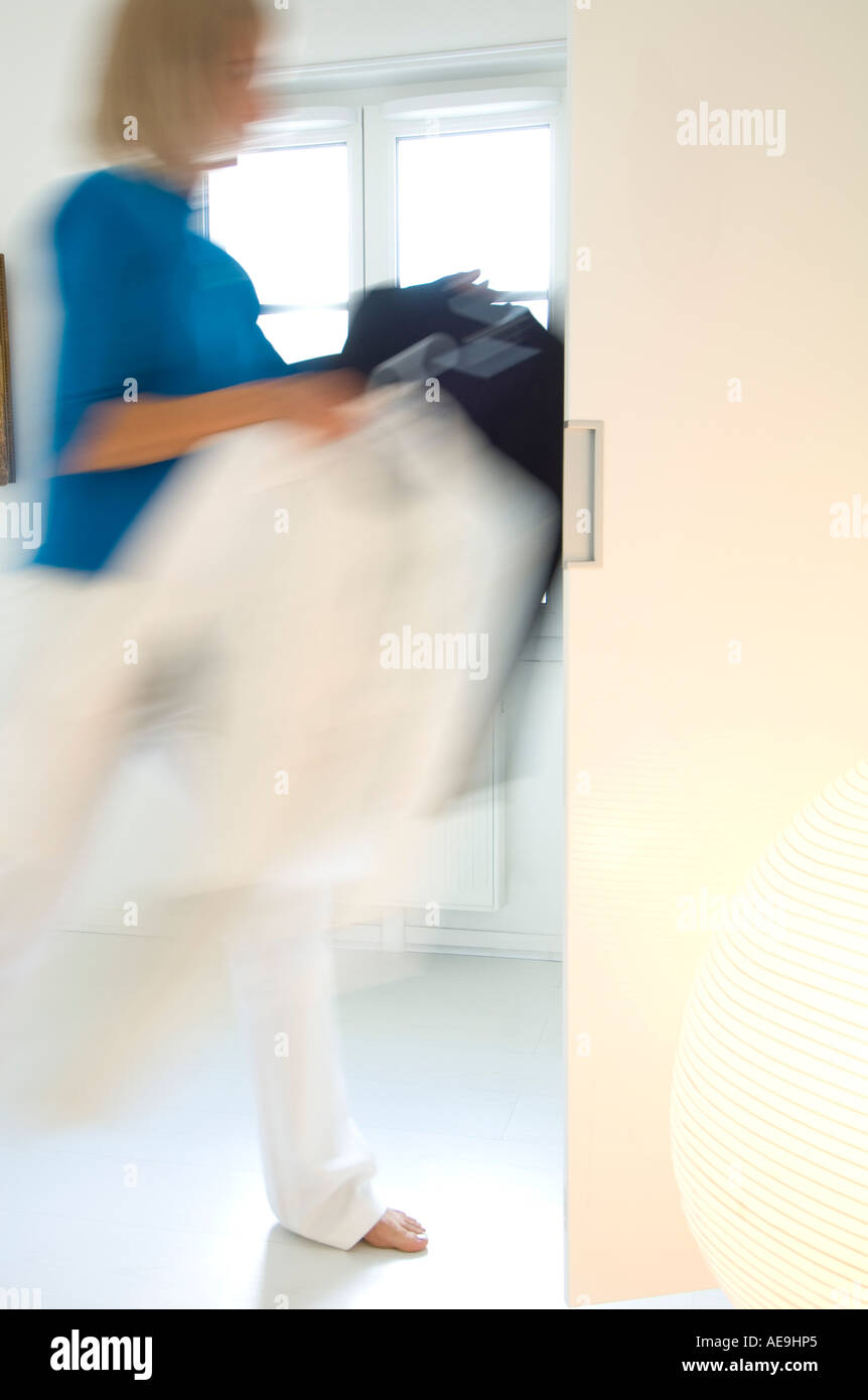 Woman carrying clothes on hangers Stock Photo - Alamy