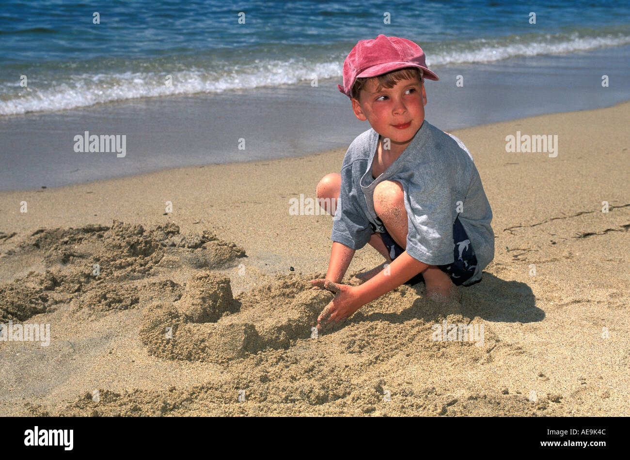 Beach Boy making sand castle on the beach Stock Photo - Alamy