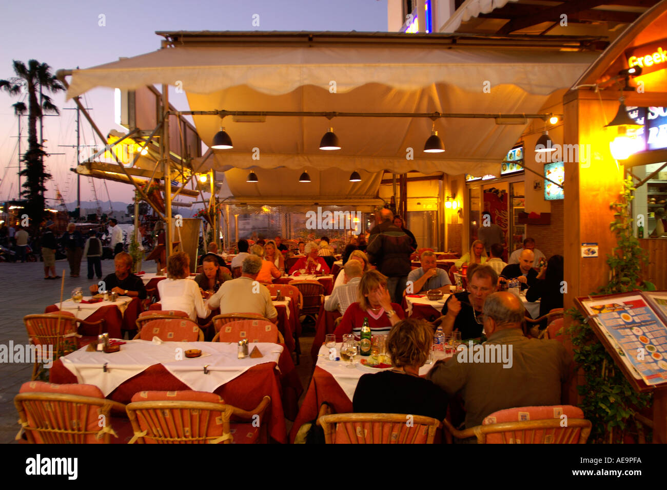 People eating at a traditional Greek Taverna early evening at Kos Town ...